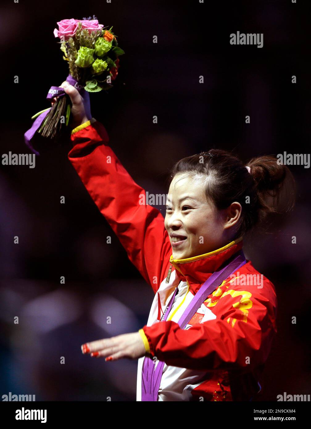 China's Wang Mingjuan holds flowers during a medals ceremony after ...