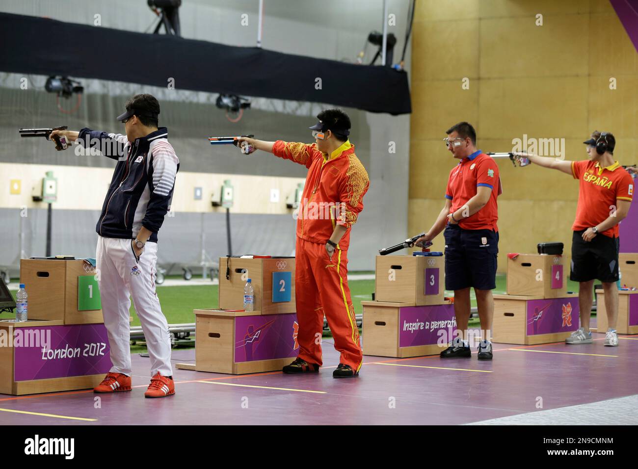 Competitors shoot during the men's 10-meter air pistol final at the ...