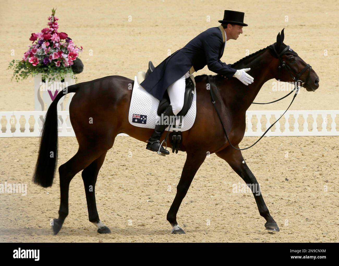 Australia's Sam Griffiths gives his horse Happy Times a pat after ...