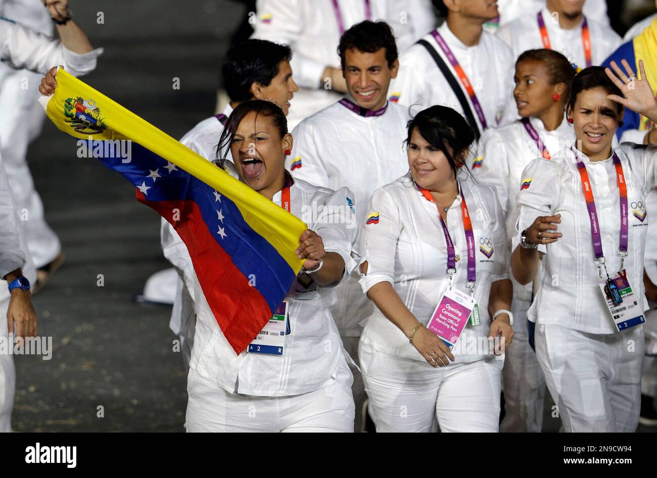 A Venezuelan athlete waves her national flag as she walks with ...