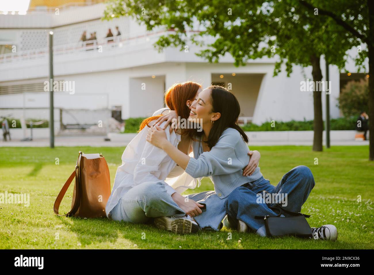 Young Beautiful Smiling Asian Girl With Closed Eyes Hugging Her Redhead