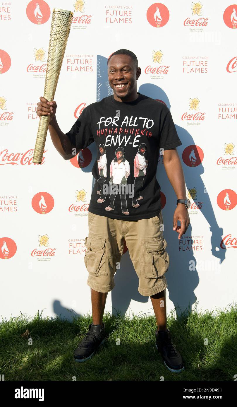 British singer Dizzee Rascal holds the Olympic Torch before he performs ...