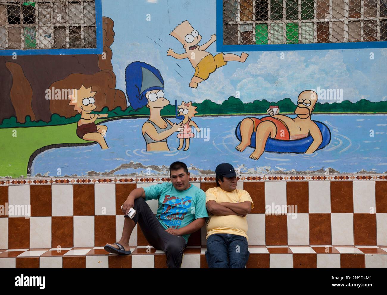Inmates sit on a bench, backdropped by a mural of the The Simpsons at ...