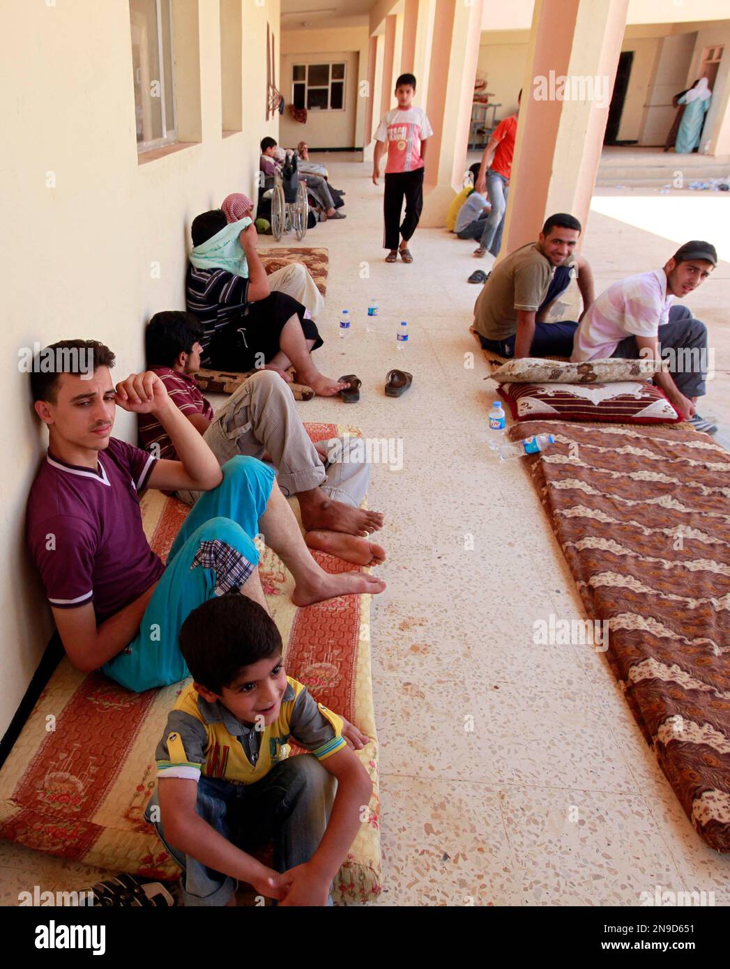 Syrian refugees rest as they arrived to a border crossing by the Iraqi ...