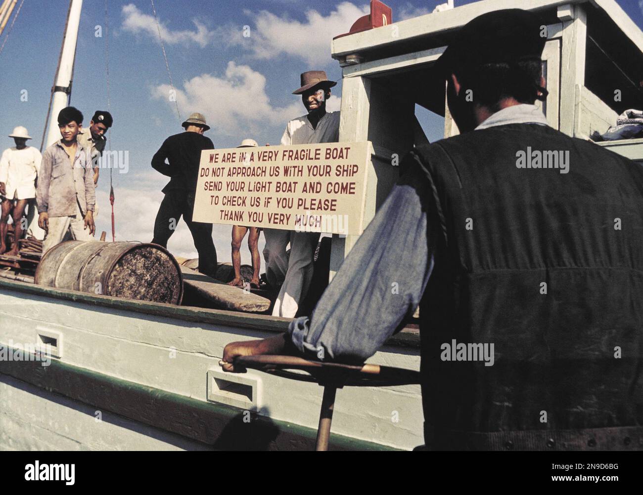 Crewmembers of fishing junk display a sign to warn U.S. Navy and ...