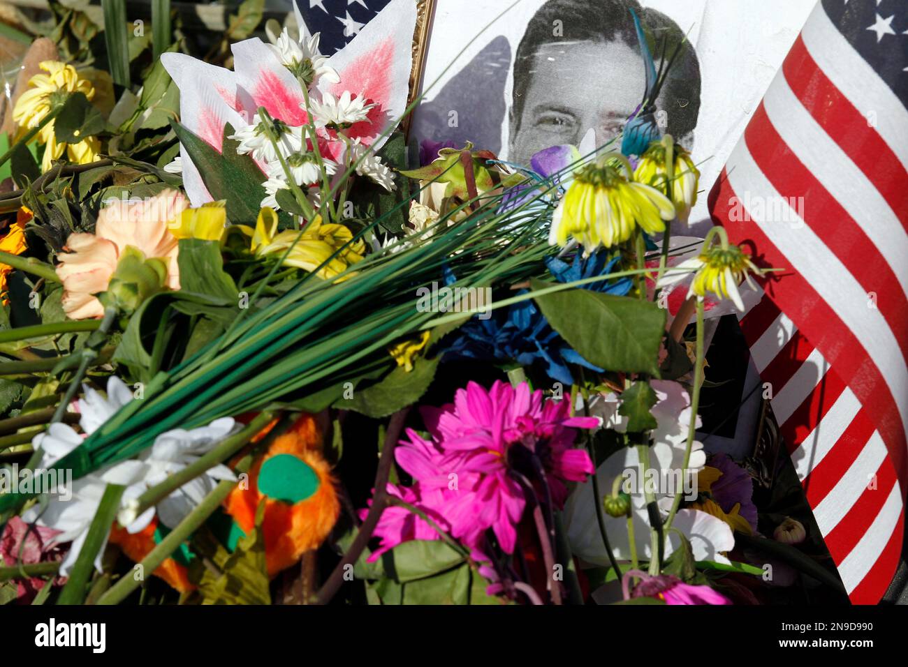 A picture of Gordon Cowden is nearly covered with flowers at the ...