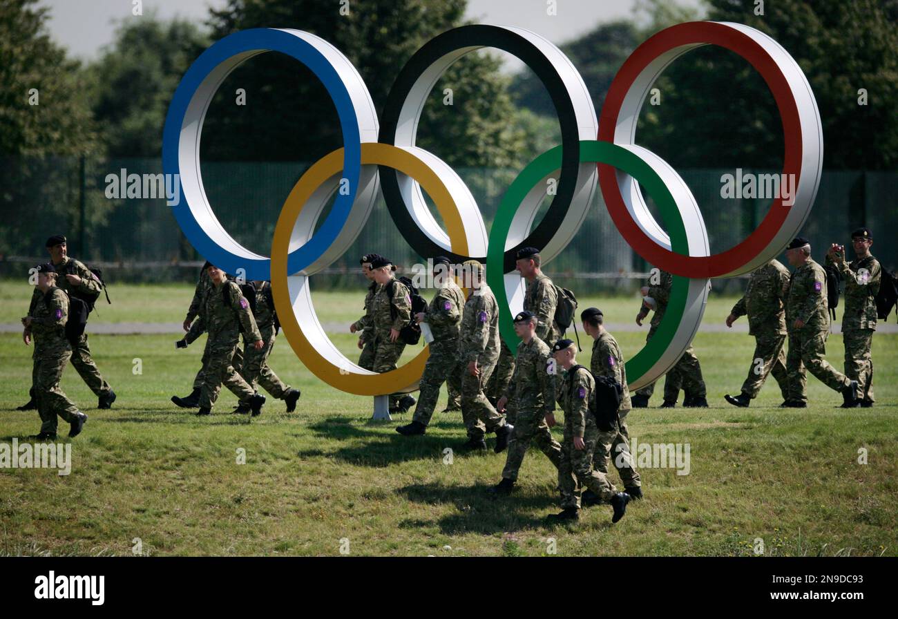 Members of a British army reserve unit walk past the Olympic rings on ...