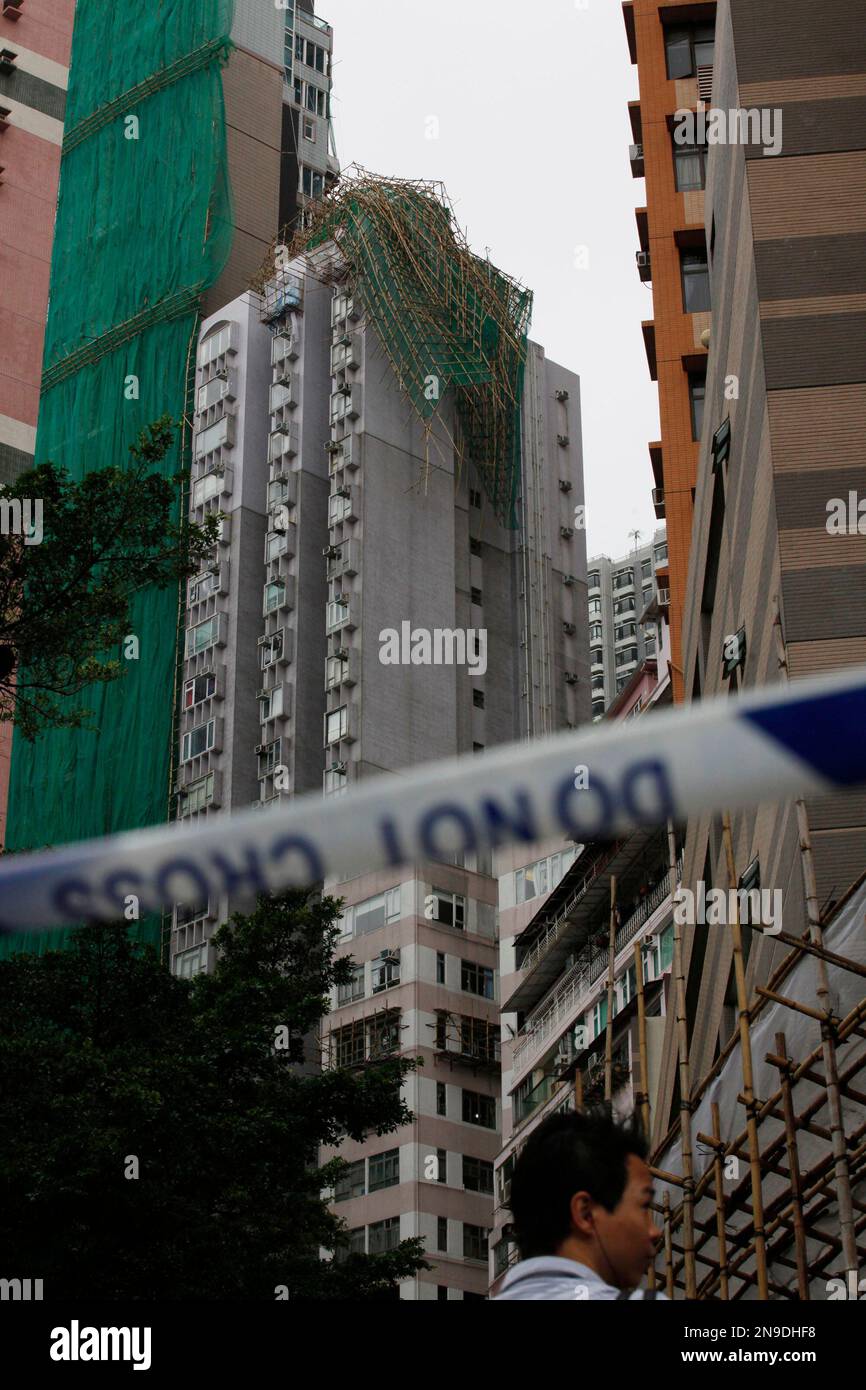 A pedestrian walks in front of collapsed scaffolding caused by typhoon ...