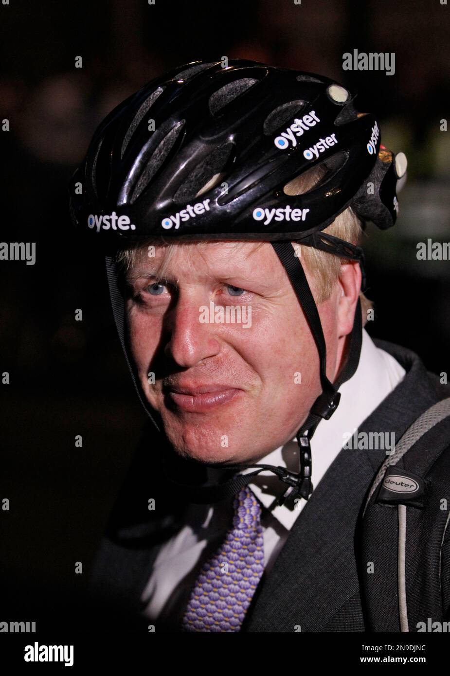 London mayor Boris Johnson, wearing a bicycle helmet talks to the media ...