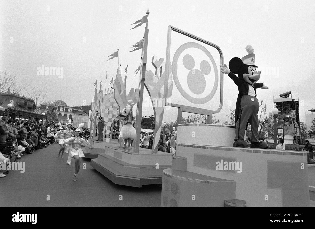 Mickey Mouse leads other Disney characters in a parade in front of ...