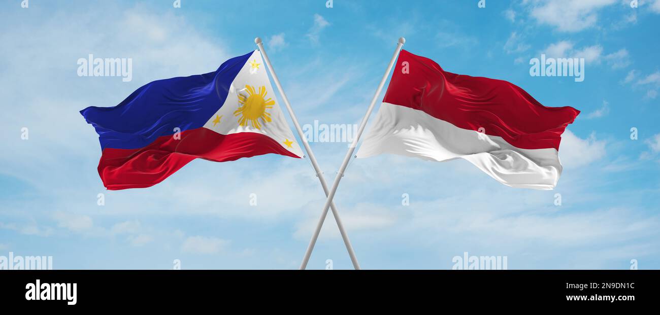 two crossed flags Indonesia and Philippines waving in wind at cloudy ...