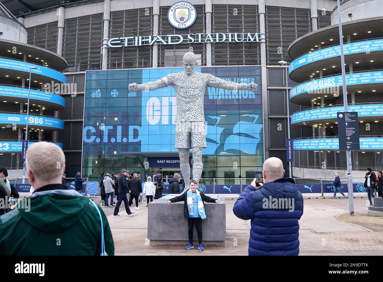 General view as Manchester City fans take photos in front of a statue ...