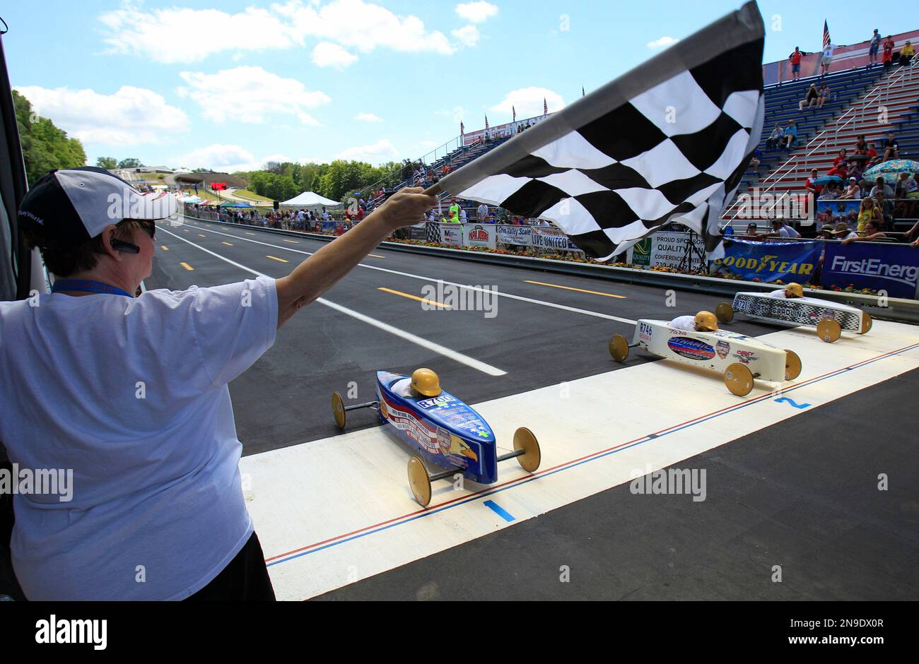 Flagger Janet Schroeter waves the checkered flag as racers cross the ...