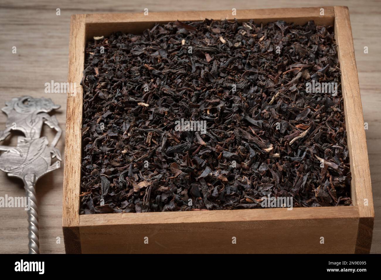 Wooden box with indonesian Java Melange dried tea leaves close up and a ...