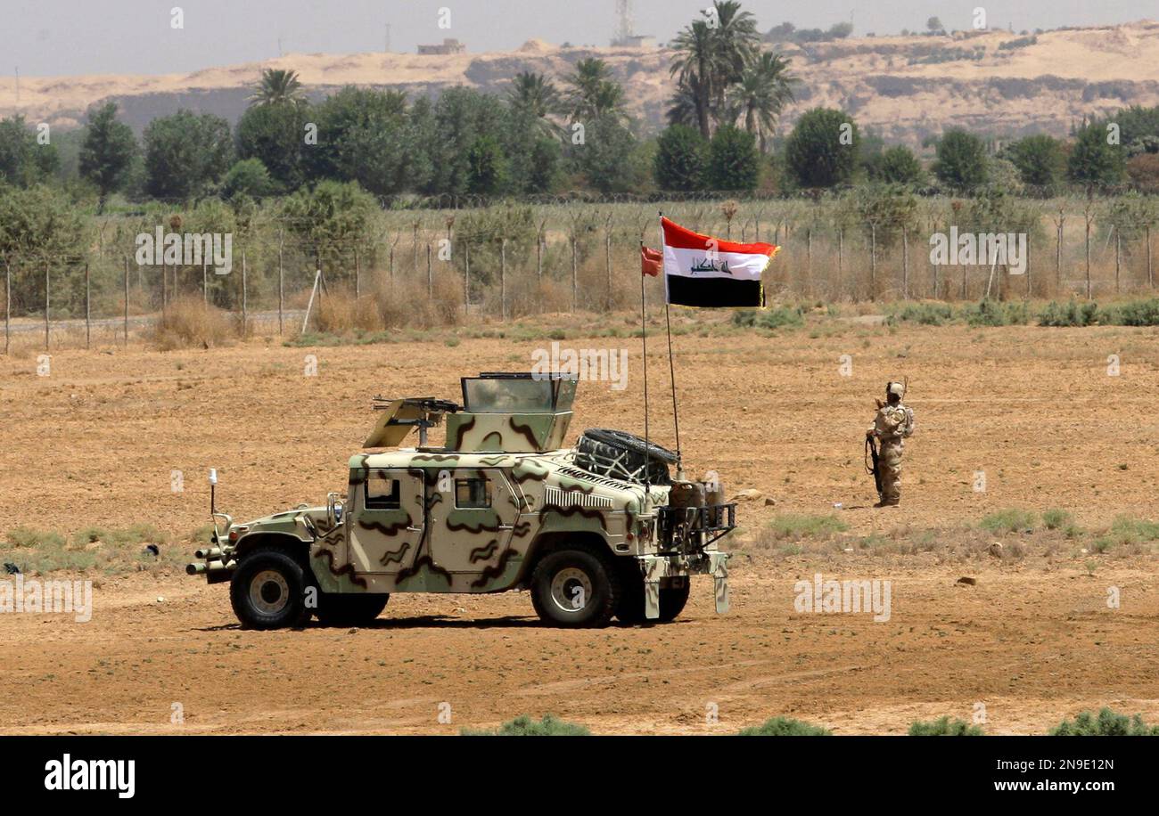 An Iraqi soldier stands guard in Qaim, located in the Euphrates river ...