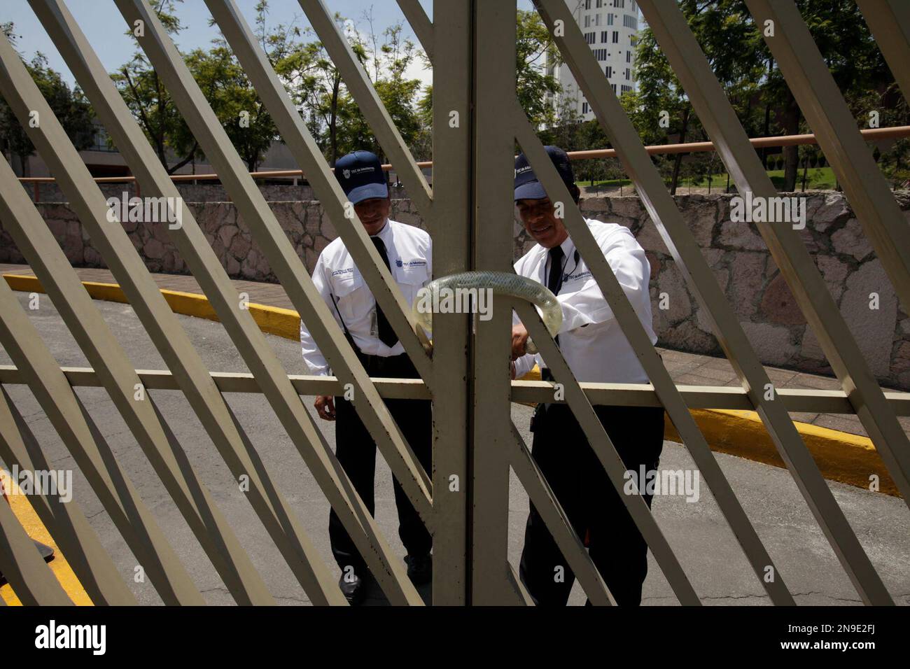 Security guards lock the gate after a mail bomb exploded at the ...