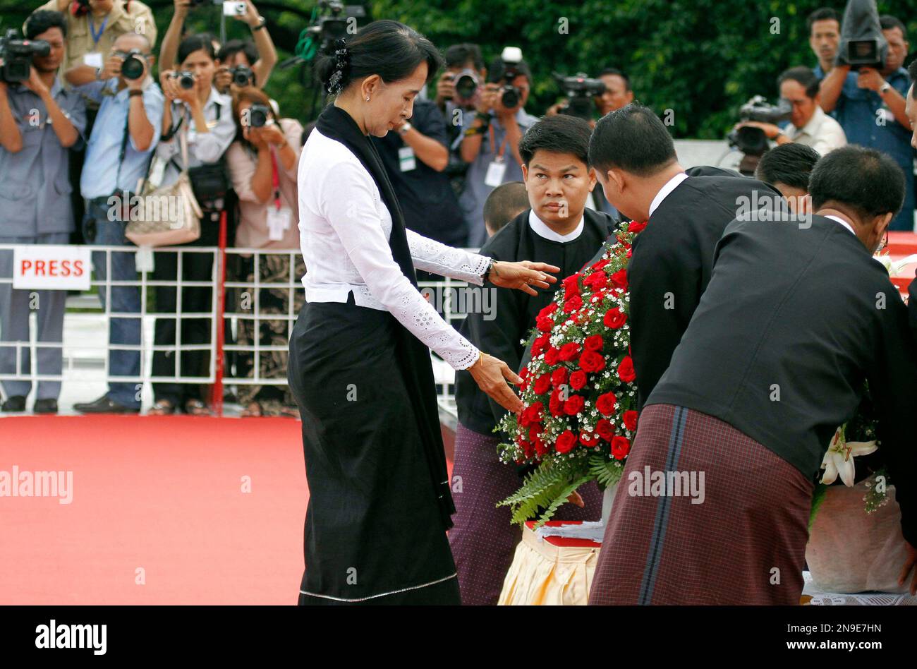 Myanmar opposition leader Aung San Suu Kyi, center, lays flowers at the ...