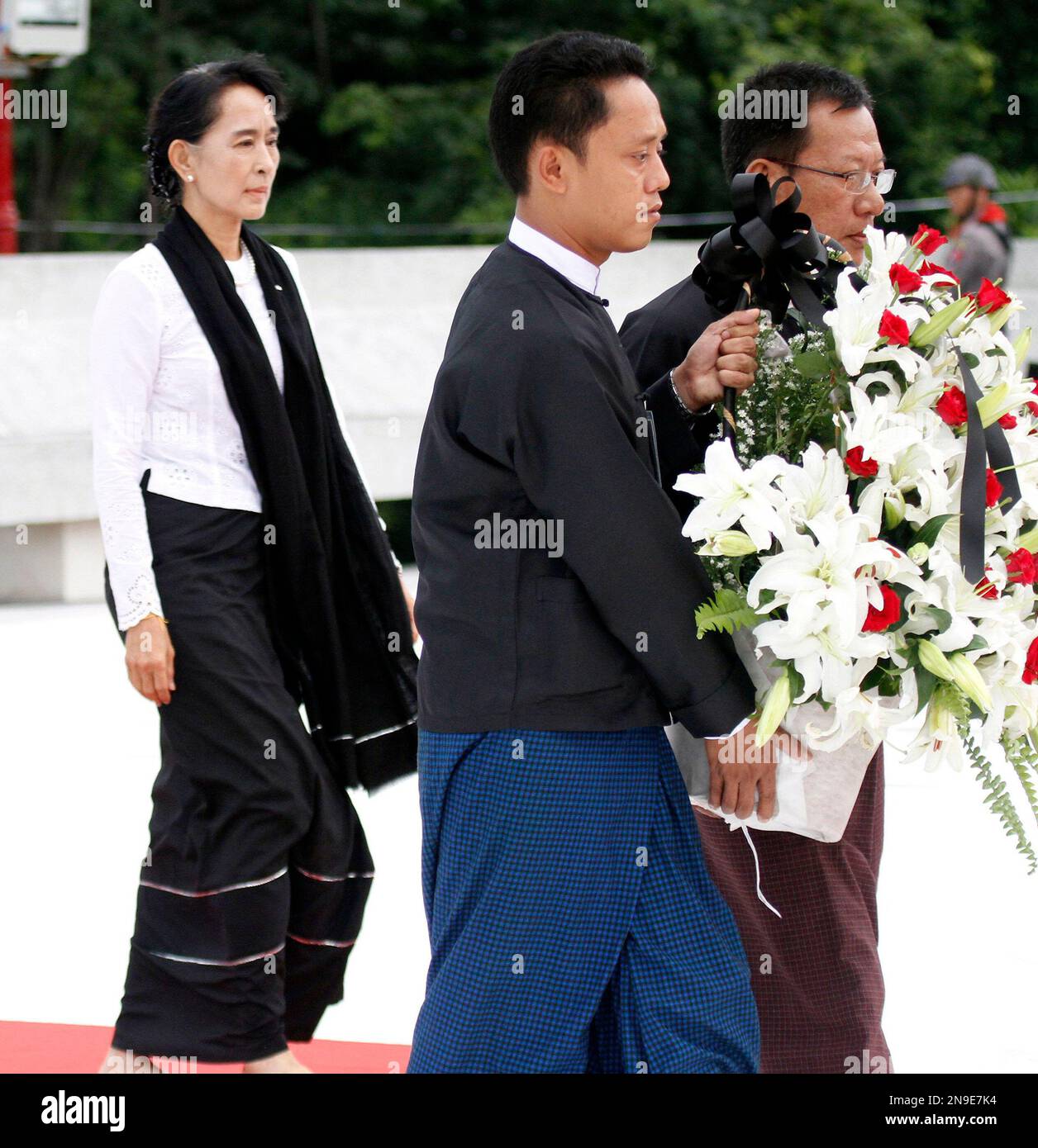 Myanmar opposition leader Aung San Suu Kyi, left, arrives to lay ...