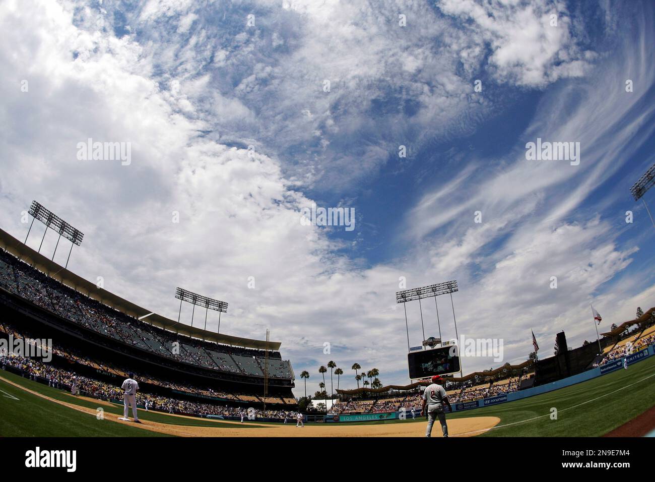In this photo made with a fisheye lens, clouds drift during a baseball ...