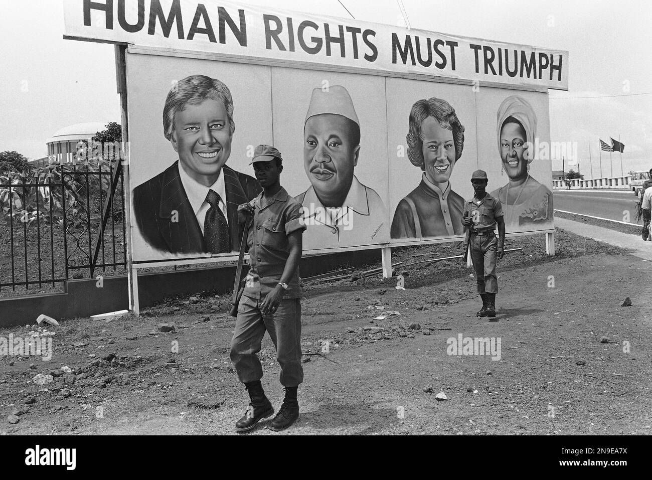 Liberian soldiers pass in front of the portraits of American President ...