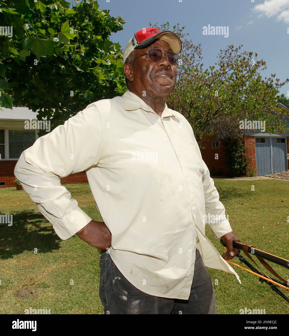 Rev. William T. Erby takes a break from mowing lawn to talk with a ...