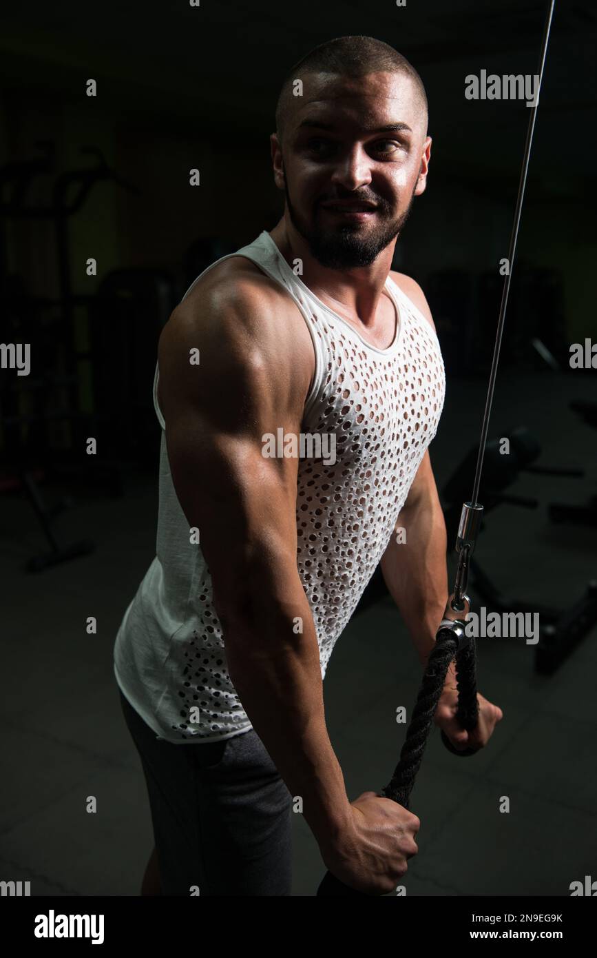 A Muscular Fitness Bodybuilder Doing Heavy Weight Exercises In Gym ...