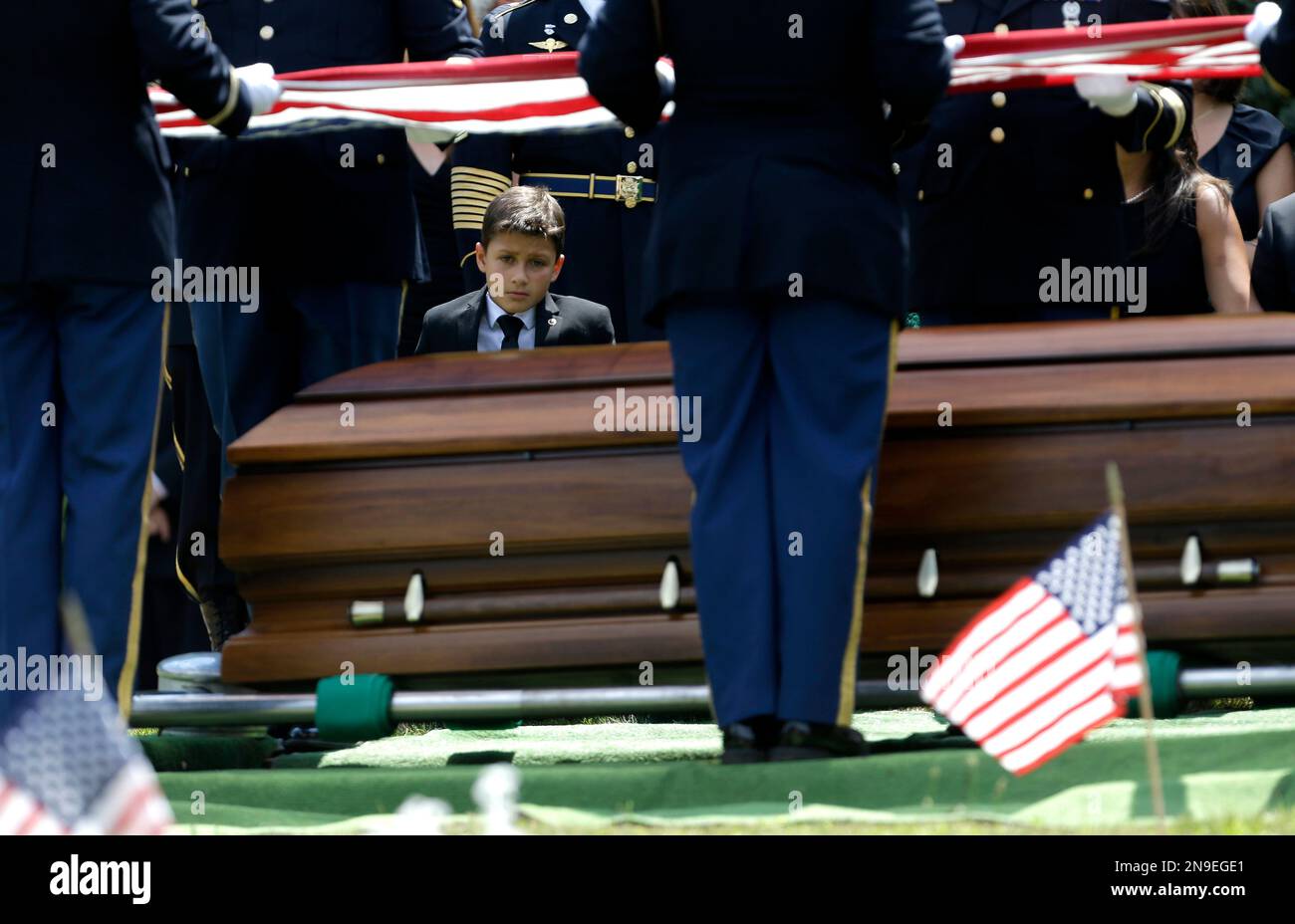Andrew Gaston looks on as pallbearers hold a U.S. flag over the casket ...