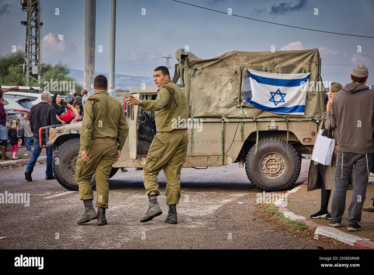 The soldiers walking in front of the Israeli armored Humvee car with ...