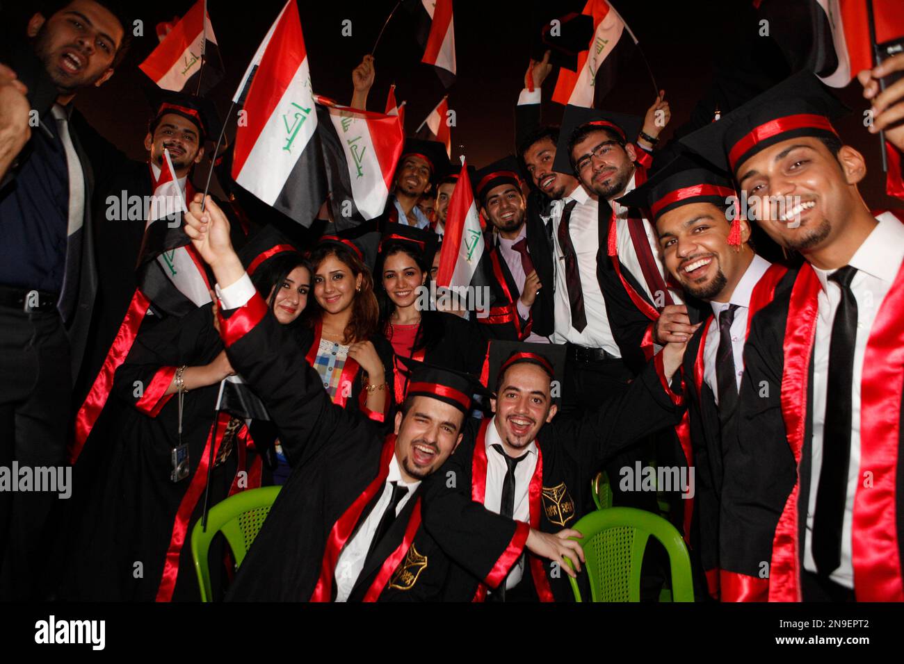Graduates wave national flags as they celebrate during a graduation ...