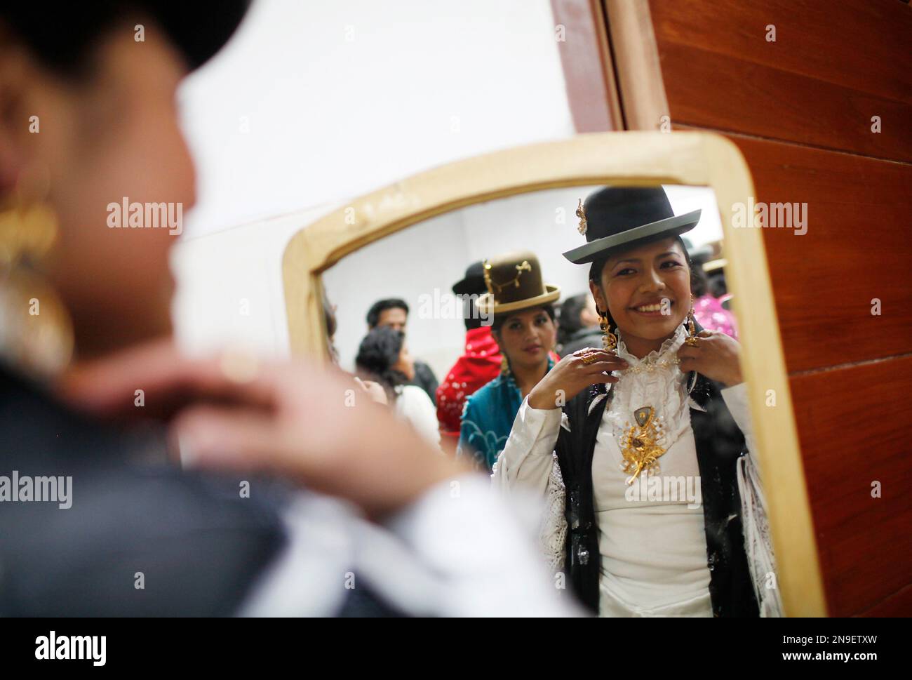 An Aymara woman looks in the mirror before performing at a Chola ...