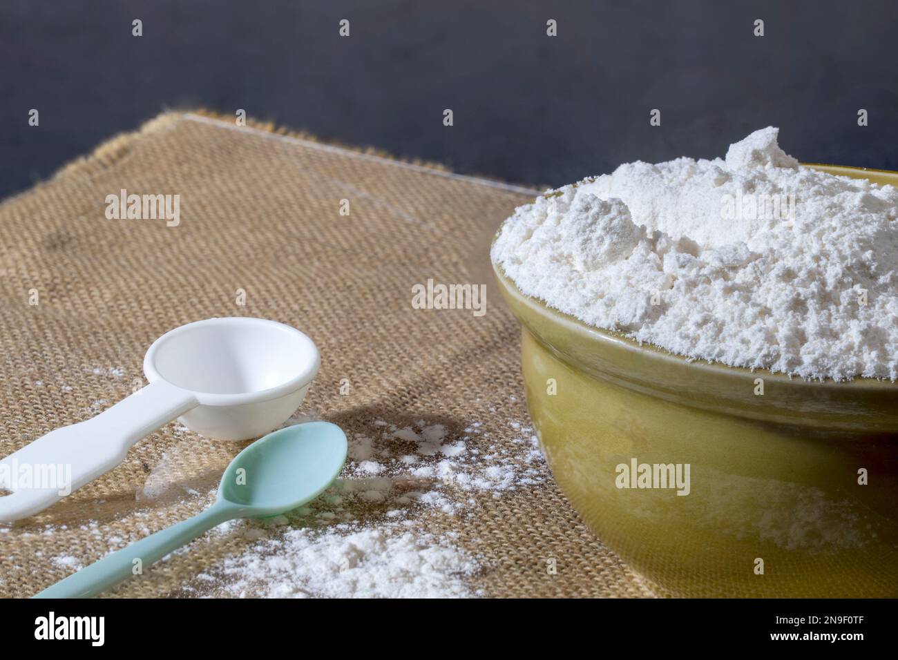 All-purpose flour in a ceramic bowl with a measuring spoon, all-purpose ...