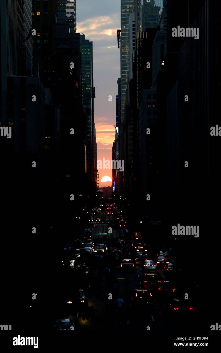 The sun sets through the middle of buildings on 42nd Street in New York ...