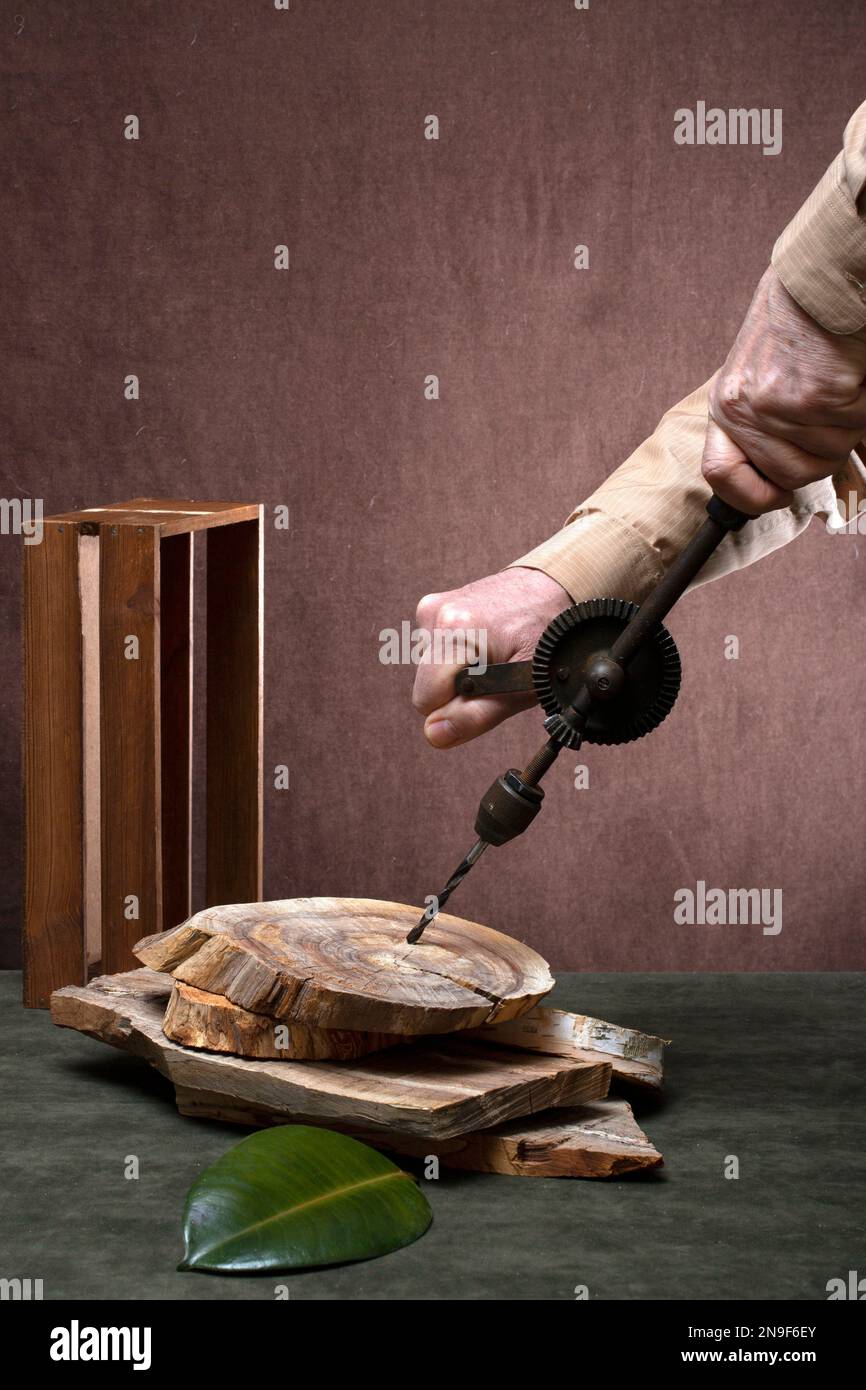 A man drills wooden boards with a hand drill Stock Photo - Alamy