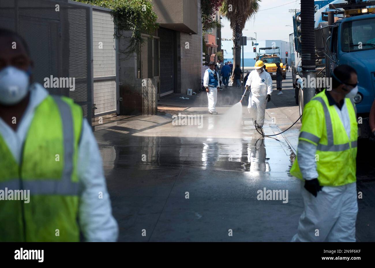 A city funded cleanup crew rinses the sidewalk on San Julian Street on ...