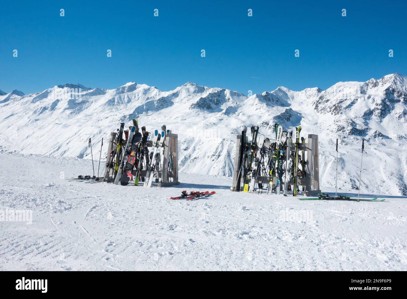 Skis and snowboards on racks outside ski restaurant with snow covered ...