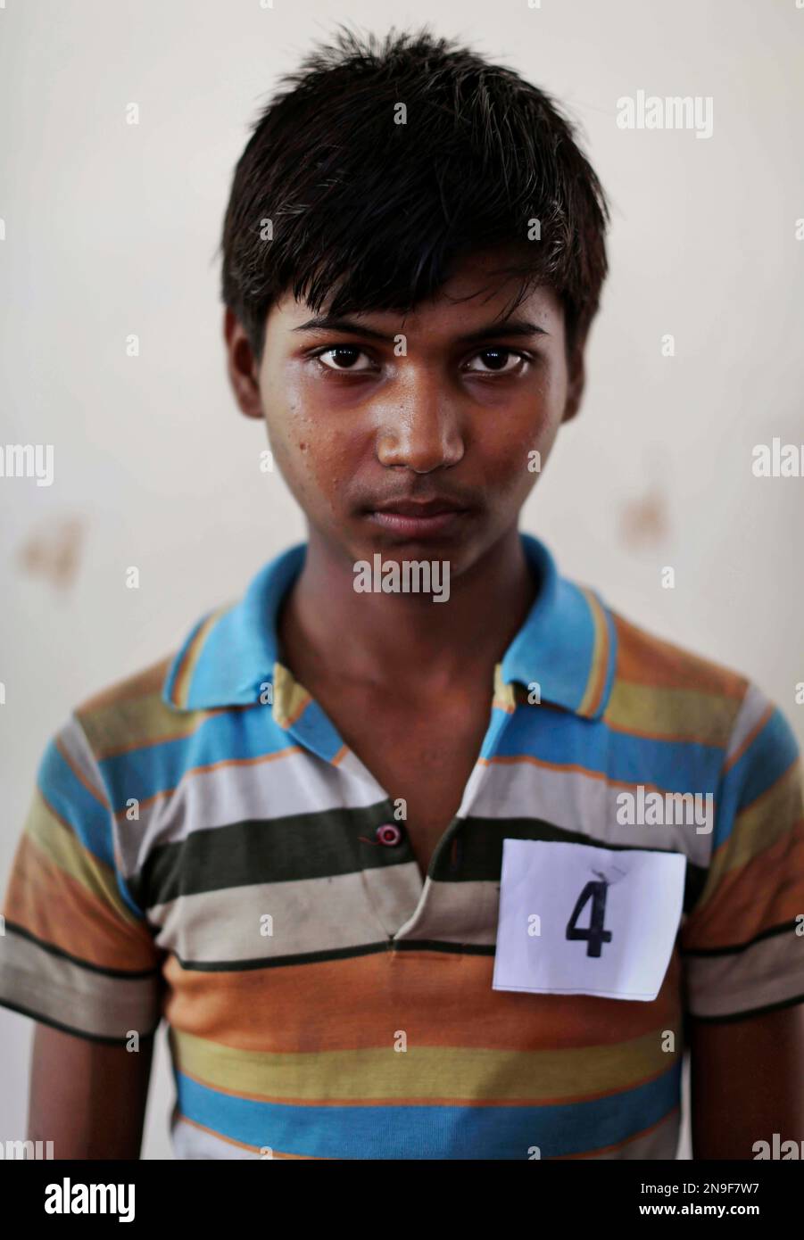 Young Indian bonded child laborer Kuldeep Mishra, 14, wears a number ...