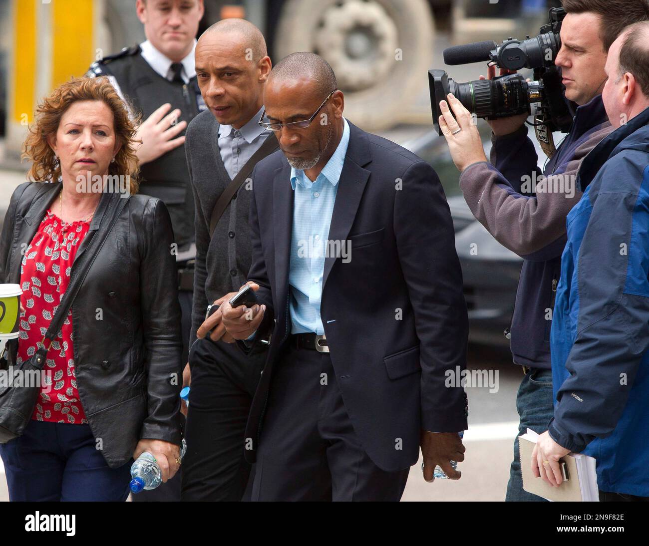 The father of Anton Ferdinand, Julian Ferdinand, center, arrives at ...