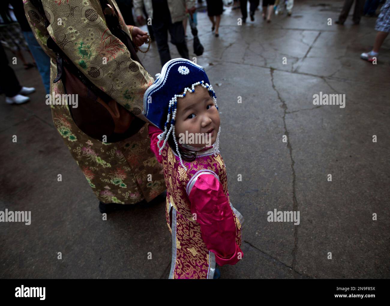 A Mongolian child in a traditional costume arrives at the Naadam ...