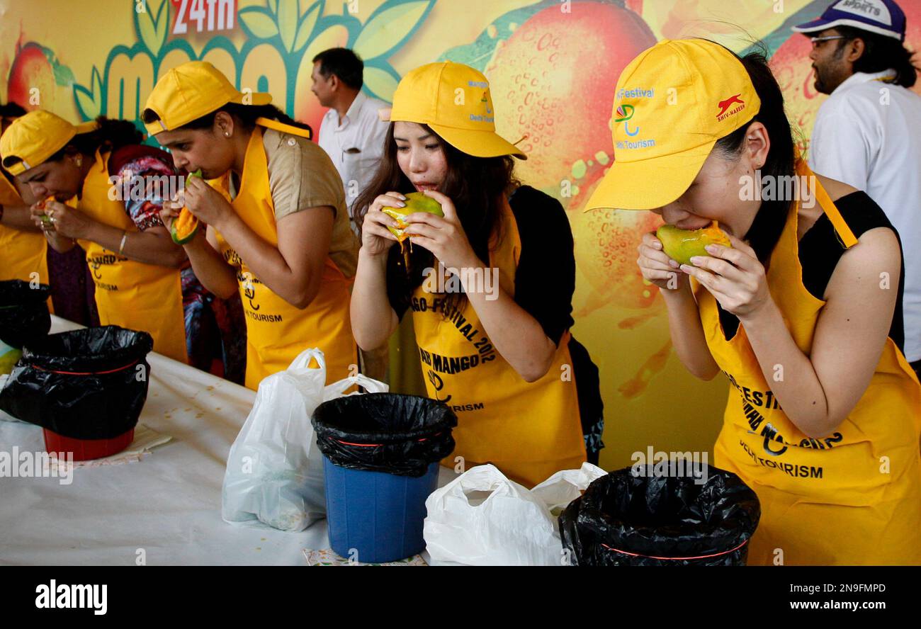 Participants eat mangoes at a mango eating contest at the annual mango ...