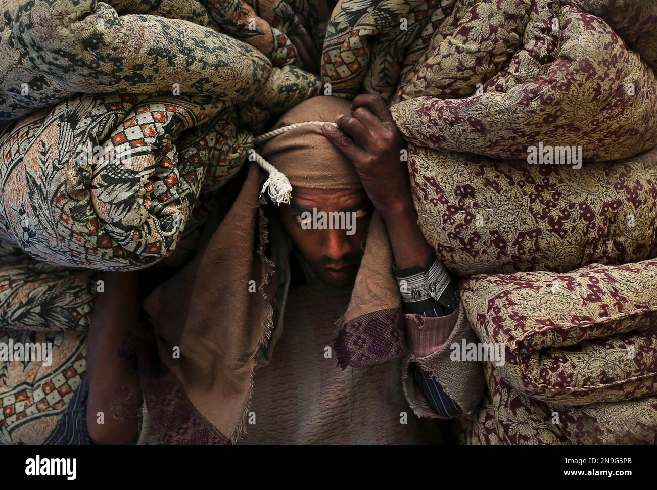 In this picture taken Friday, June 29, 2012, a Kashmiri porter carries ...