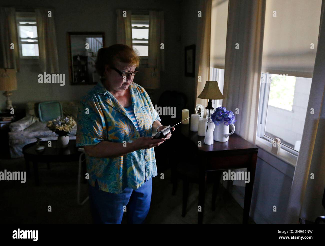 Susan Slowik tunes a battery-operated television in her living room in ...