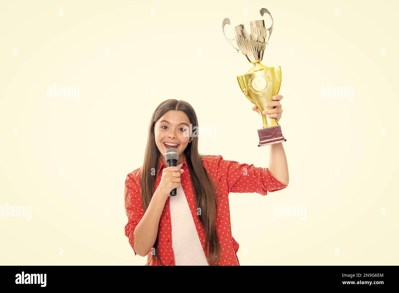Teenage girl with win cup microphone speech. Teen holding a trophy. Kid ...