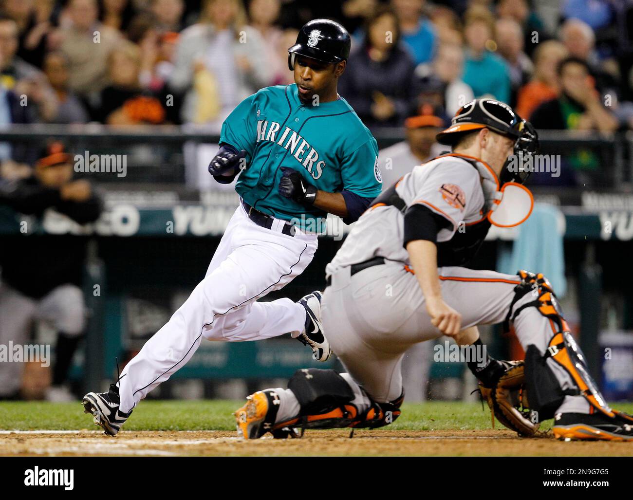 Seattle Mariners' Chone Figgins begins a slide at home as Baltimore ...