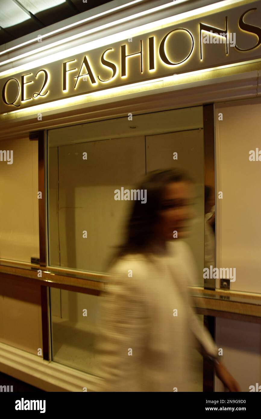 A woman passes a shop aboard the Queen Elizabeth 2 as Istithmar World ...