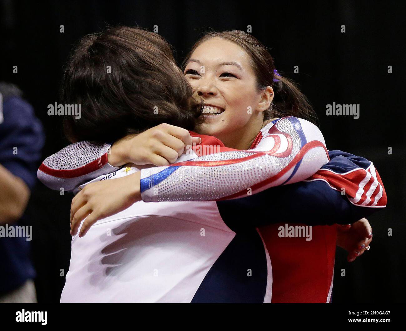 Anna Li hugs her coach after competing on the balance beam during the ...