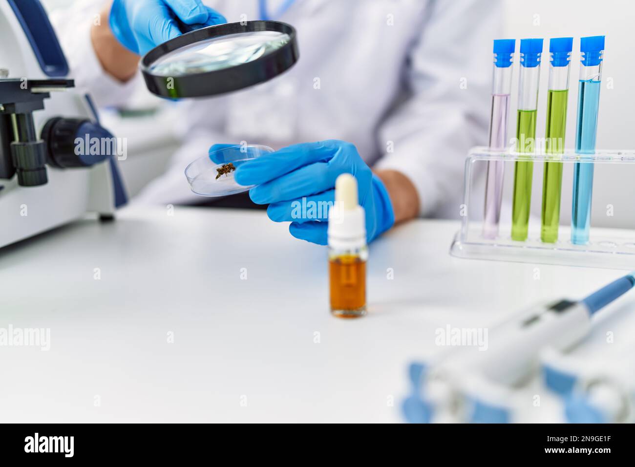 Young blond man scientist using magnifying glass at laboratory Stock ...