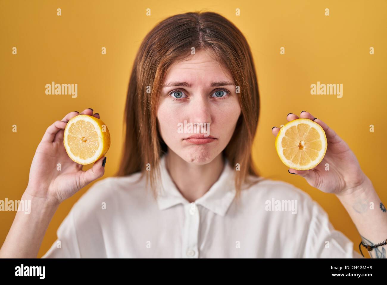 Beautiful woman holding lemons depressed and worry for distress, crying ...