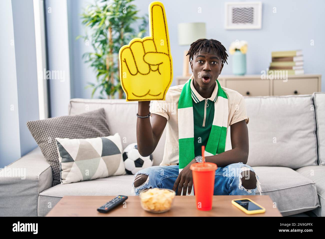 African man with dreadlocks football hooligan supporting team scared ...