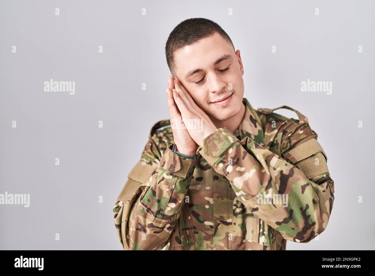 Young man wearing camouflage army uniform sleeping tired dreaming and ...