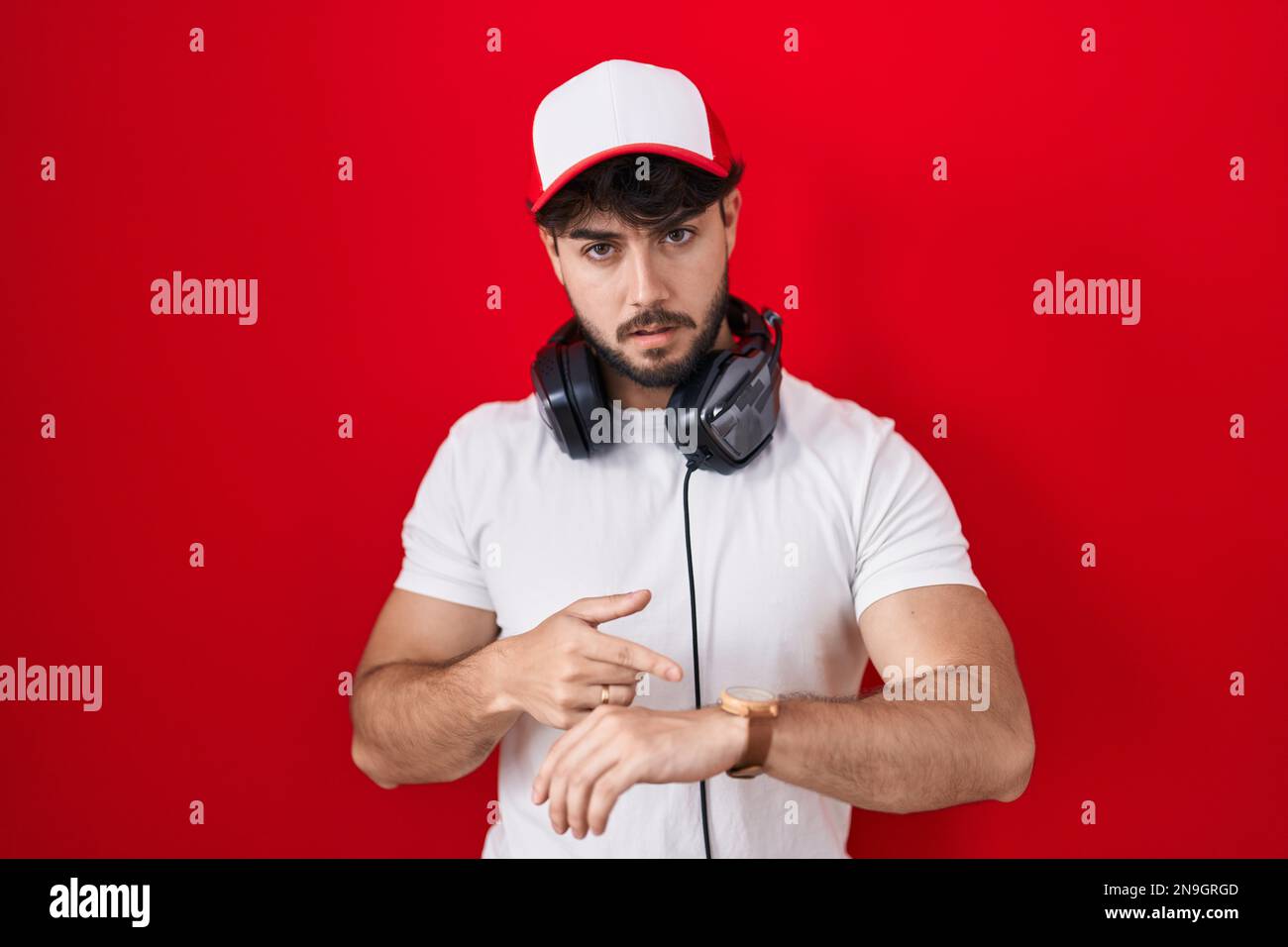 Hispanic man with beard wearing gamer hat and headphones checking the ...